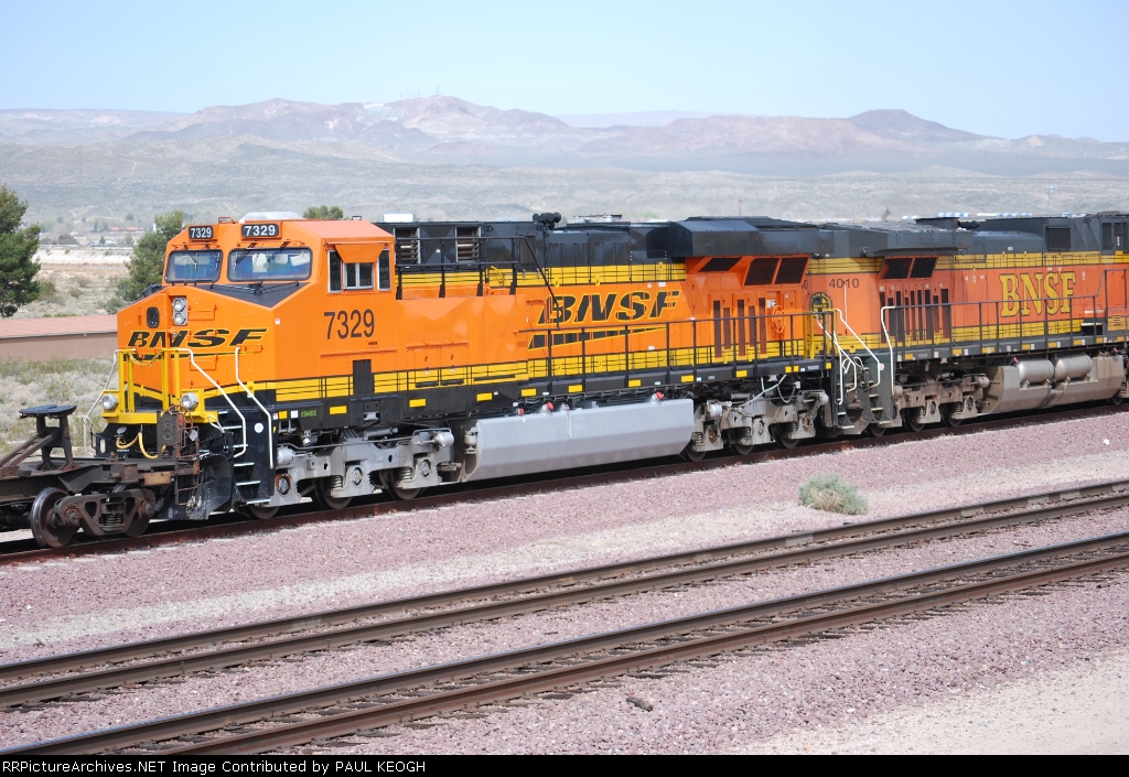 BNSF 7329 2d unit behind BNSF 4010 wait to roll west with a mty spine car consist.